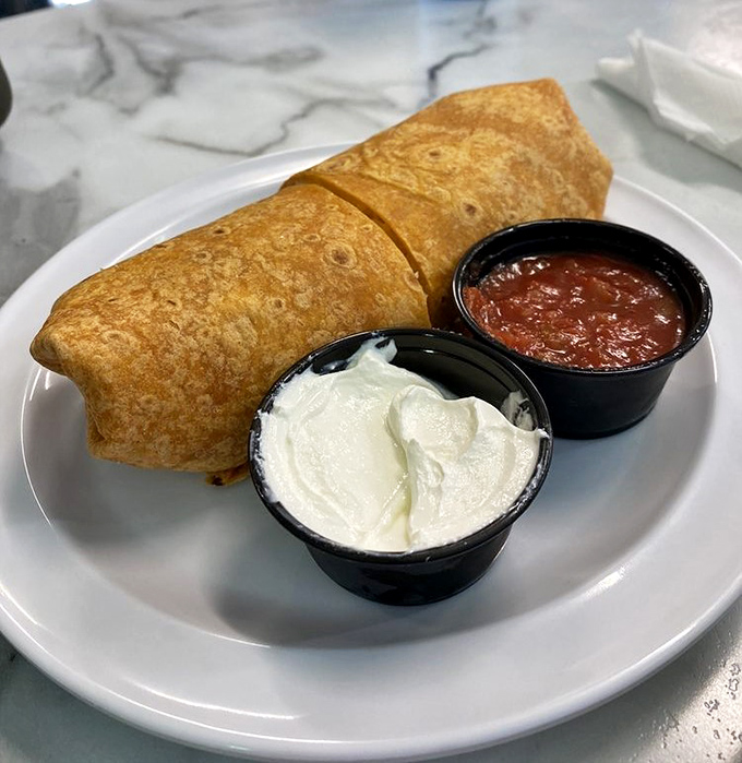 Breakfast burritos: where morning meets Mexico in a tortilla hug. Those sides of sour cream and salsa are non-negotiable companions.