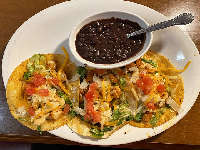 Tacos that demand to be photographed before eaten. Fresh toppings, melted cheese, and black beans that aren't just a side&mdash;they're an essential character in this story.