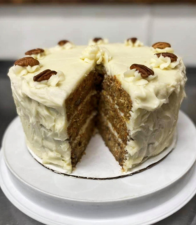 This carrot cake isn't just dessert, it's architecture—three layers of spiced perfection crowned with cream cheese frosting and pecan sentinels.