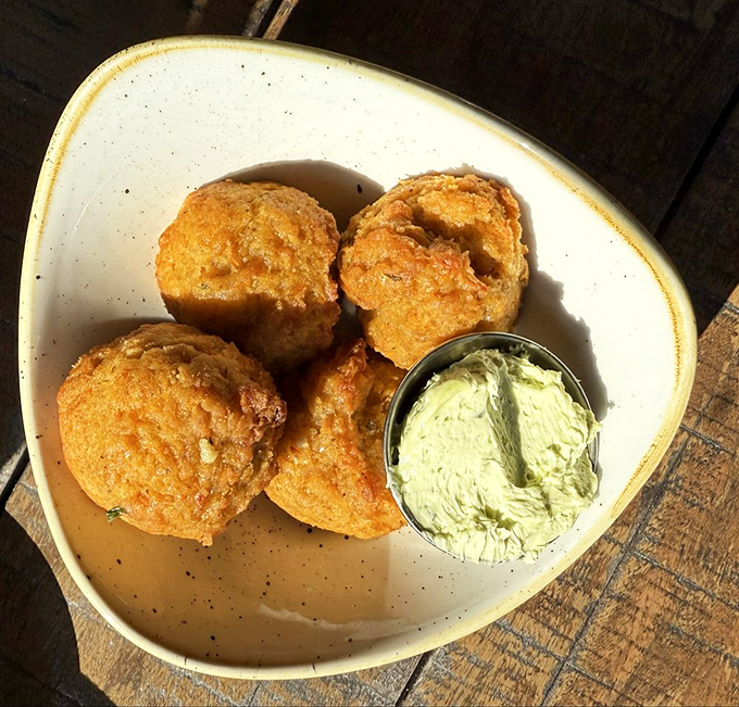 These golden orbs aren't just biscuits; they're edible proof that someone in this kitchen genuinely likes you. The herb butter is the silent wingman here.