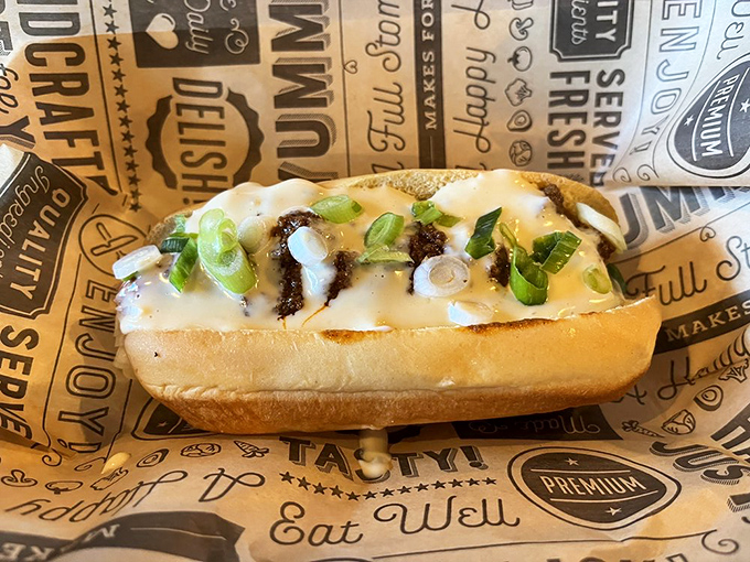 This isn't just a chili dog&mdash;it's a masterpiece of contrasts, where the soft bun cradles spicy chili and the scallions add a fresh punctuation mark.