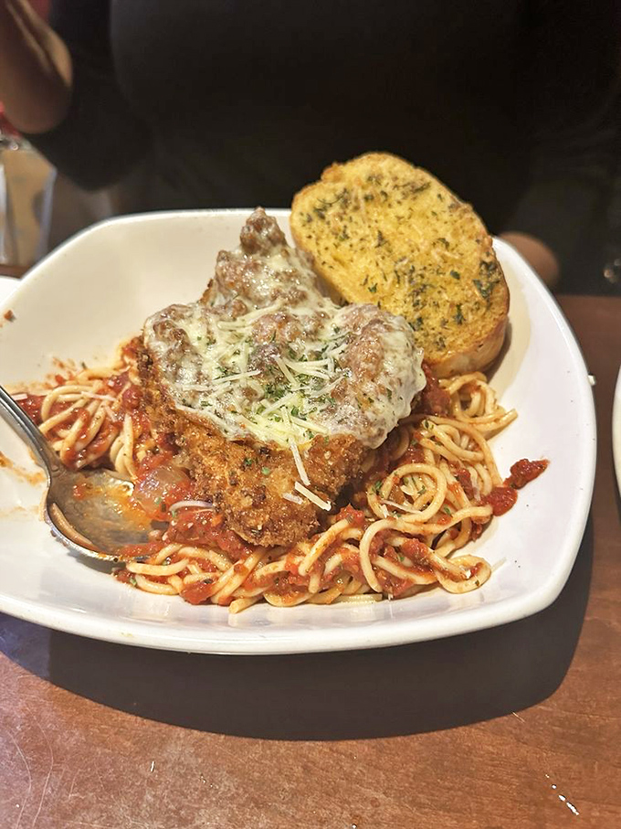 Chicken Parmesan that would make an Italian grandmother nod in approval – crispy, cheesy, saucy perfection atop a bed of pasta.