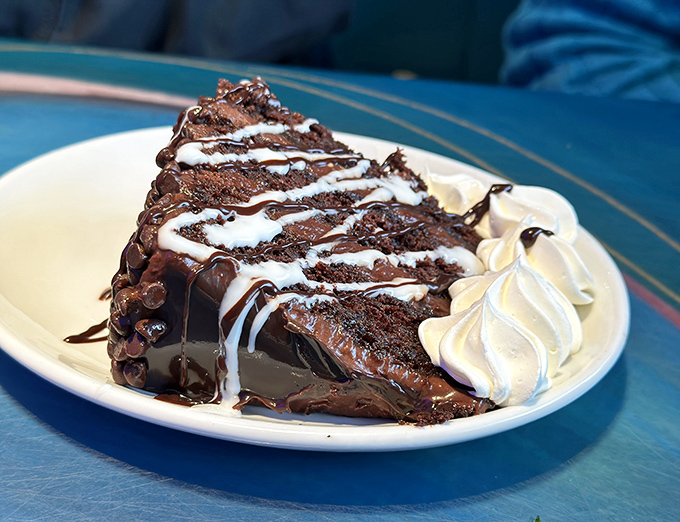 Chocolate cake so decadent it should require a permission slip. Those chocolate drizzles are basically edible art with whipped cream exclamation points.