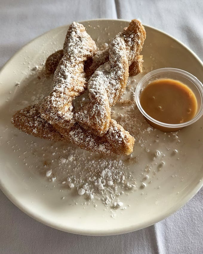 These churros aren't just fried dough – they're crunchy, cinnamon-sugar coated vehicles for delivering pure joy, especially when dipped in caramel sauce.