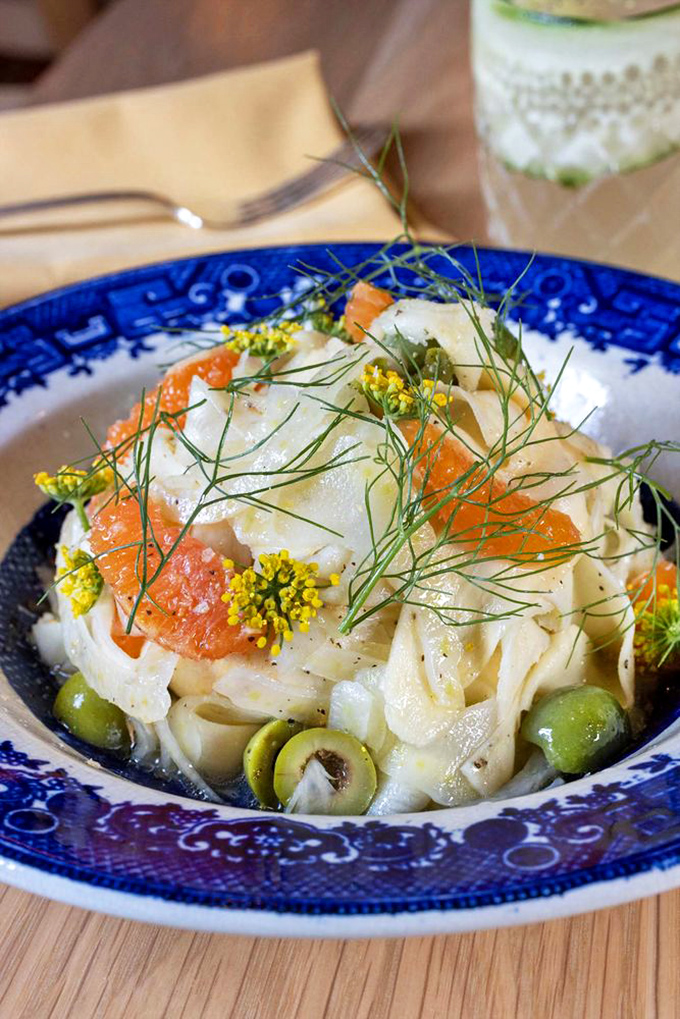 Pasta swimming in citrus brightness with olives providing salty punctuation marks—a bowl of sunshine you eat with a fork.