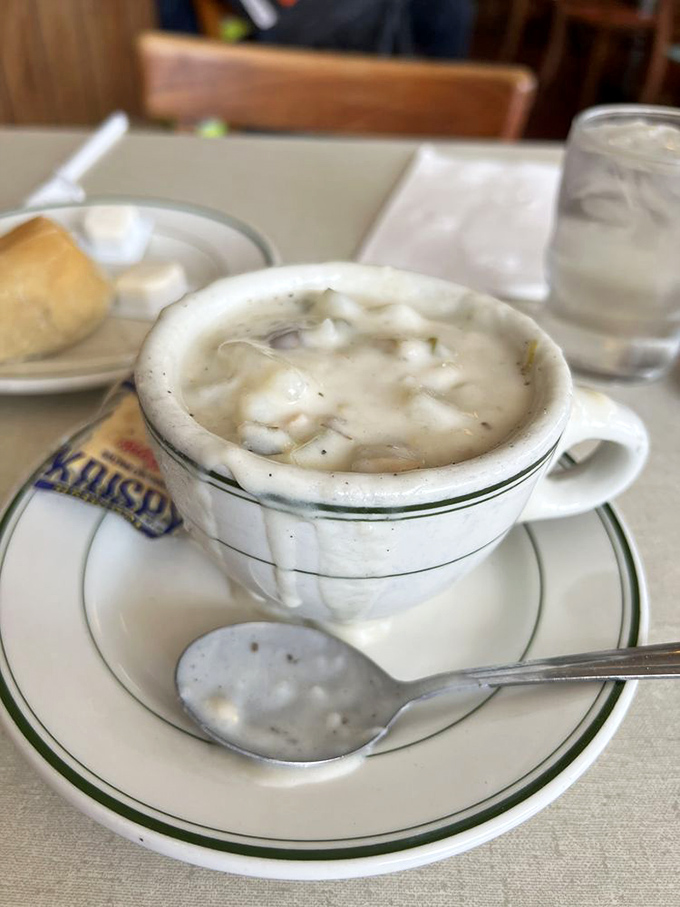A cup of clam chowder so hearty it could qualify as a meal, with each spoonful offering a warm, briny hug from the inside.