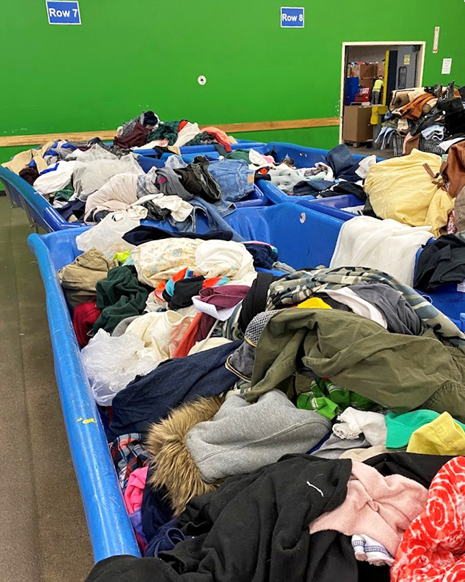 Bargain hunters in their natural habitat, mining for textile gold. The concentration on these faces rivals chess grandmasters mid-tournament.