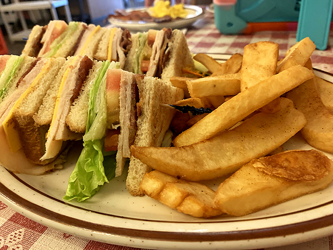 The Club Car Sandwich arrives like a skyscraper of satisfaction, with fries that remember what potatoes should taste like.
