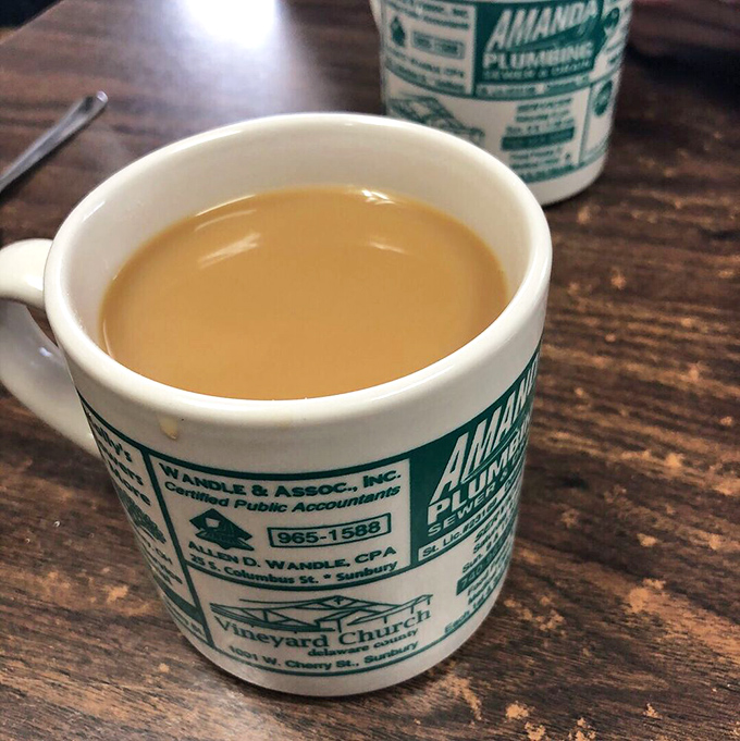 The coffee comes in mugs advertising local businesses&mdash;a small-town tradition more authentic than any artisanal coffee shop's carefully curated aesthetic.