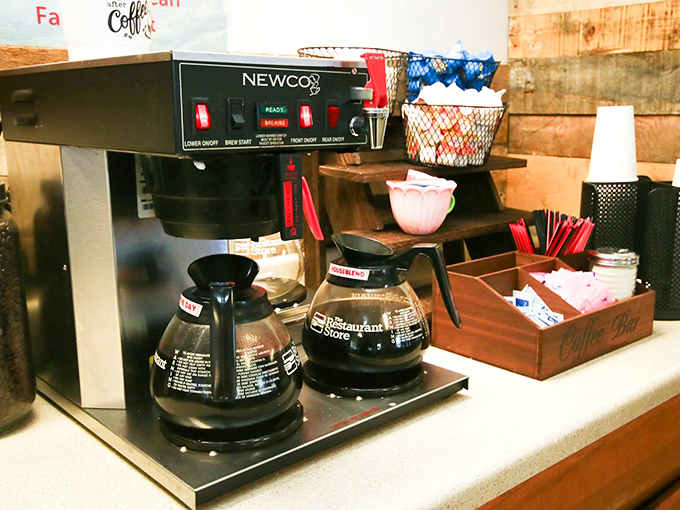 The coffee station stands ready like a loyal friend who knows exactly what you need after facing morning traffic on Route 13.