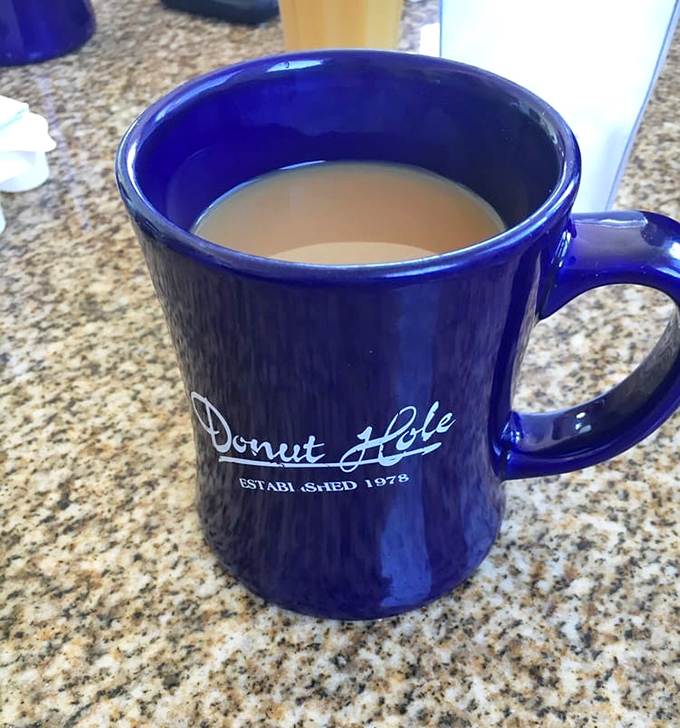 The iconic blue mug—holding liquid motivation that keeps coming until you've solved all the world's problems over breakfast.