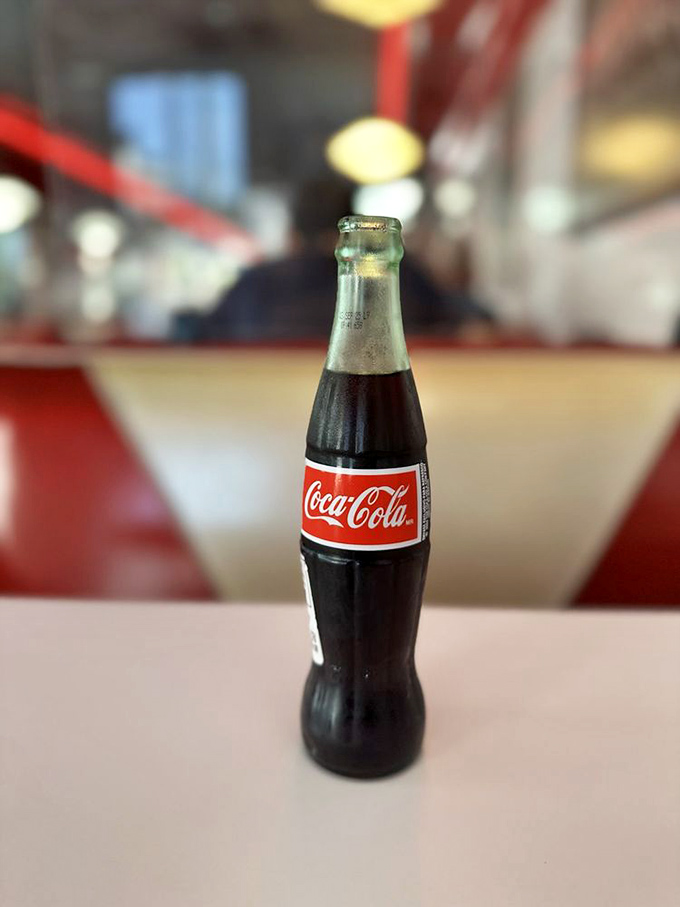 That iconic glass bottle of Coca-Cola isn't just a beverage; it's a time machine in liquid form, perfectly at home in this retro setting.