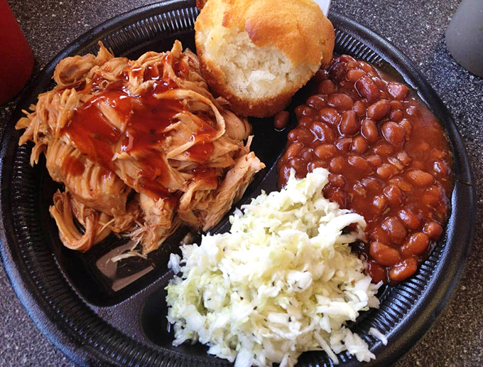 The holy trinity of Southern comfort: pulled pork kissed by smoke, beans that have simmered to perfection, and slaw that cuts through the richness with bright crunch.