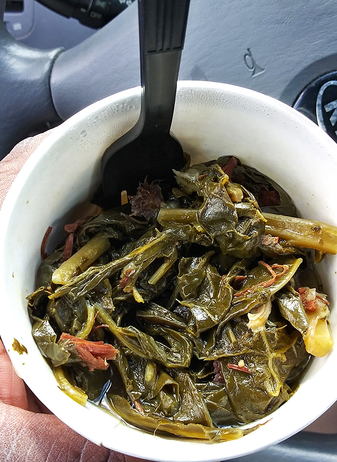 These collard greens have clearly been simmering with smoked meat for hours, creating the kind of side dish that steals the spotlight.
