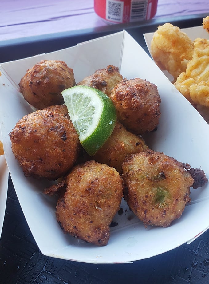 Conch fritters: golden-brown spheres of Caribbean-influenced heaven. That lime wedge isn't just garnish&mdash;it's an essential flavor companion.