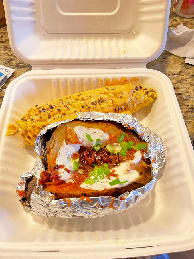 Corn on the cob and a loaded potato&mdash;proof that in barbecue land, even the vegetables dress up for the occasion.