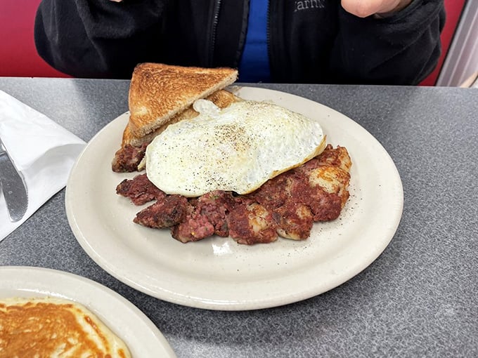 Corned beef hash topped with a perfectly cooked egg&mdash;this plate isn't trying to win a beauty contest, just your eternal breakfast loyalty.