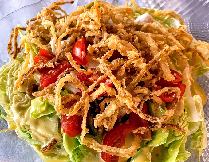 A salad that doesn't apologize for being a salad&mdash;crisp greens topped with those addictive fried onion wisps that turn vegetables into an event.