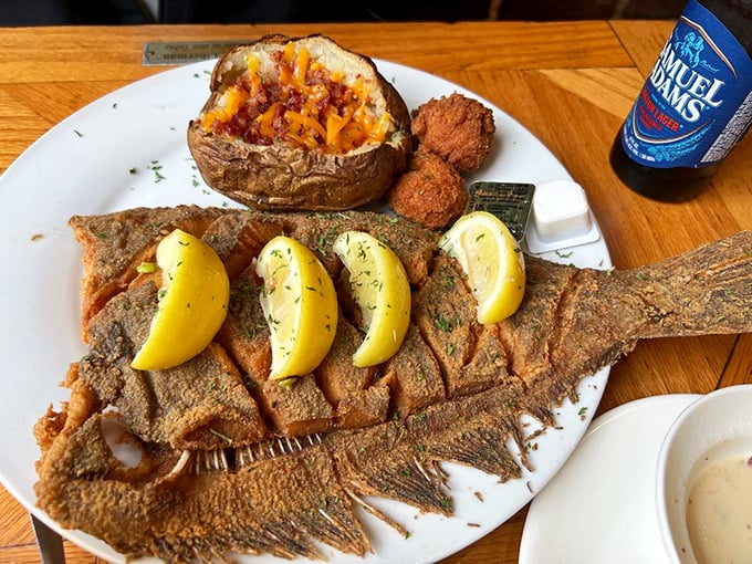 The Crispy Flounder arrives like a golden-armored knight, accompanied by a loaded baked potato and hushpuppies fit for royalty.