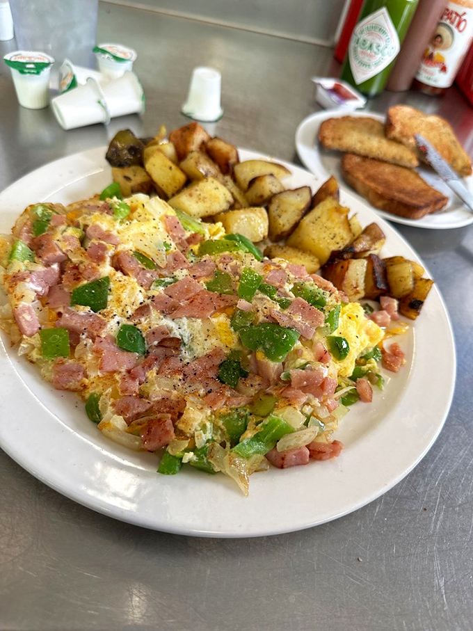 This Denver omelet showcases the art of perfectly folded eggs loaded with ham, peppers, and melted cheese.