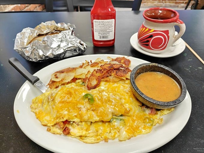 A Denver omelet in its natural habitat, served with the kind of hash browns that make you forget about your carb-counting app.