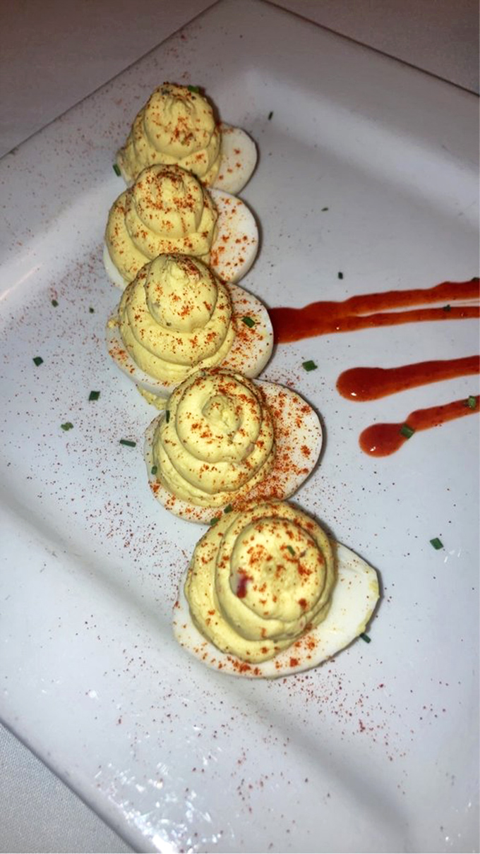 Deviled eggs lined up like culinary soldiers, each one topped with a perfect dollop that whispers, "You know you want me."