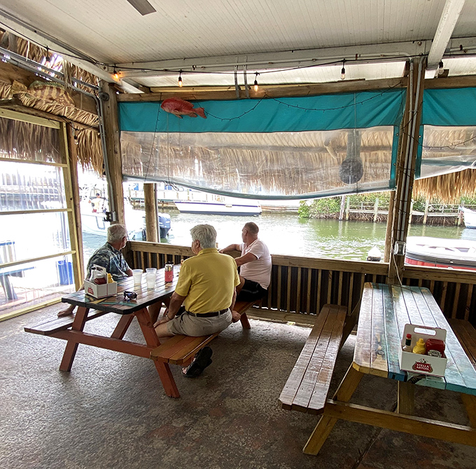 Waterfront dining where the conversation flows as naturally as the tide. These gentlemen have clearly discovered the secret to retirement.