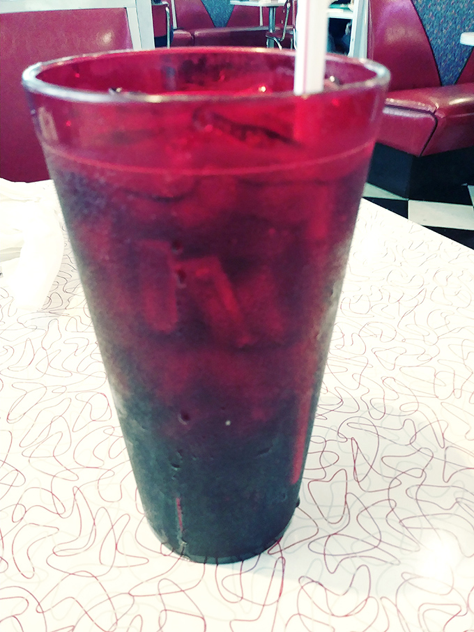 That ruby-red beverage isn't just a drink, it's a companion to your meal. Cold, refreshing, and served in a glass that means business.