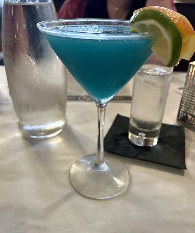 This electric blue martini isn't just a drink, it's a conversation piece. Garnished with citrus and served with enough ice water to remind you tomorrow still exists.