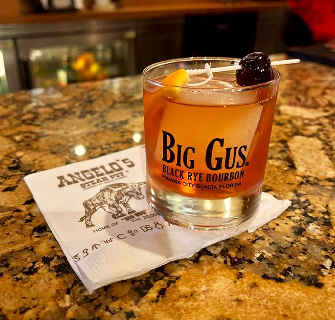 The "Big Gus" cocktail sits regally on its napkin throne—proof that Angelo's takes its liquid refreshments as seriously as its steaks.