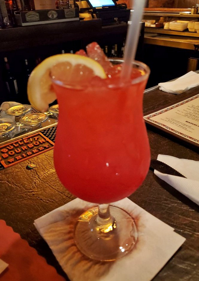 A vibrant hurricane-style cocktail that says, "Yes, we're serious about our meat, but we know how to have fun too."