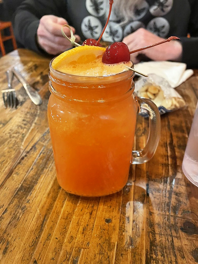 A mason jar cocktail garnished with cherries and citrus &ndash; because sometimes your burger deserves a well-dressed companion.