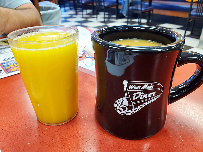 Orange juice so vibrant it could power a small city, sitting beside the diner's signature mug&mdash;a vessel that's witnessed countless morning revelations and refills.