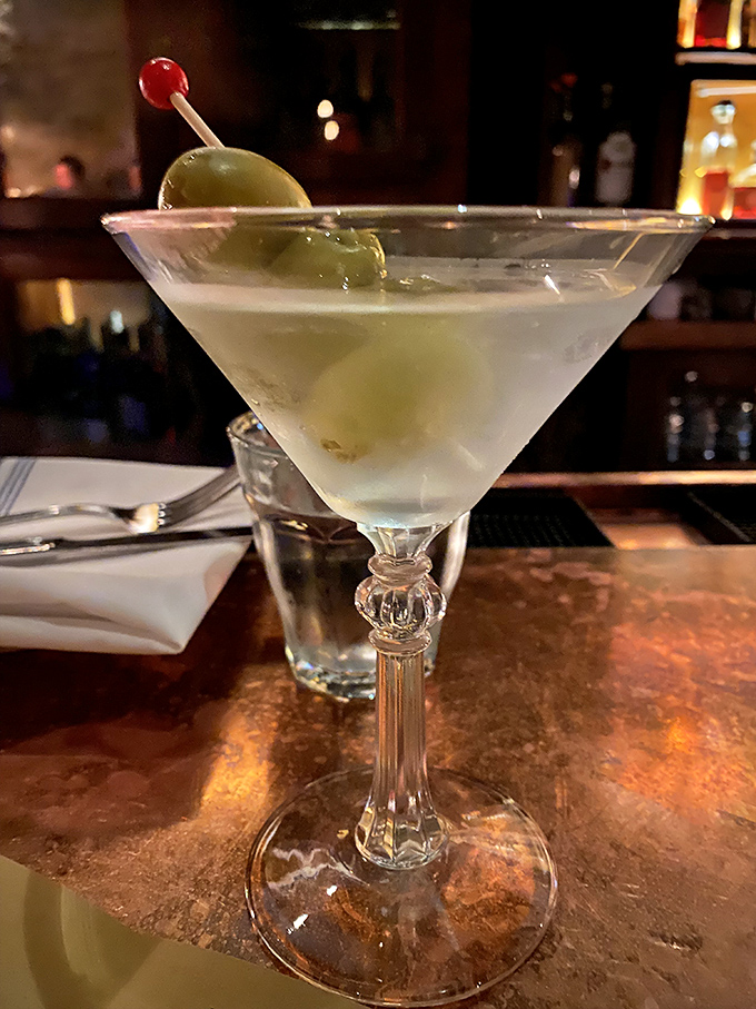 A perfectly crafted martini with olives standing at attention. This isn't just a cocktail; it's liquid civilization in a glass.