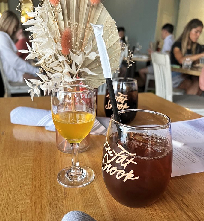 Cocktails at The Fat Snook come with a side of coastal ambiance. That branded glass isn't just holding a drink&mdash;it's holding liquid vacation.
