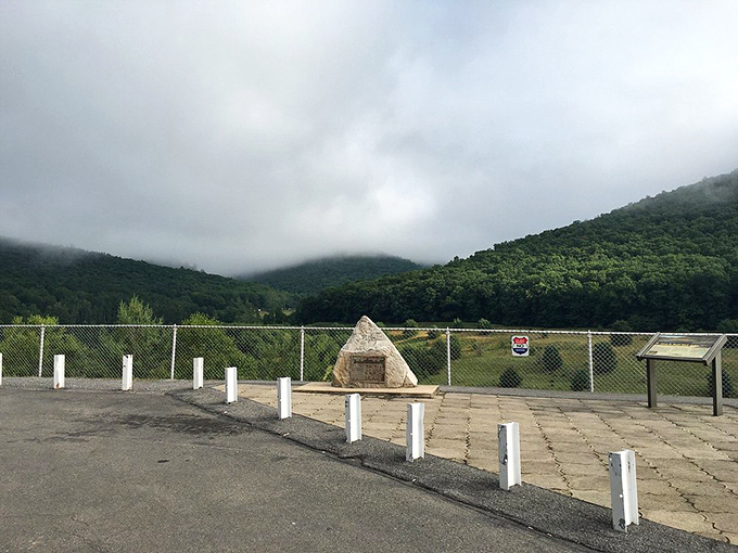 Misty mountains shrouded in clouds like a scene from Middle-earth. The memorial stone stands sentinel, preserving stories of waters tamed.