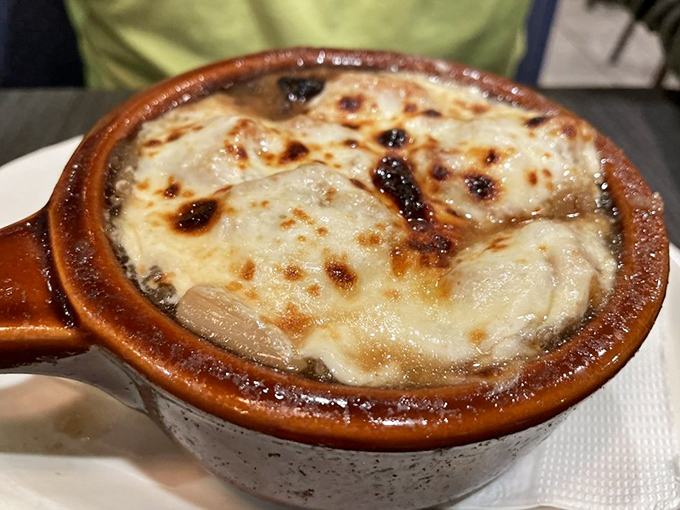 French onion soup under a blanket of melted cheese is like wearing a comfort food sweater—warming you from the inside out.