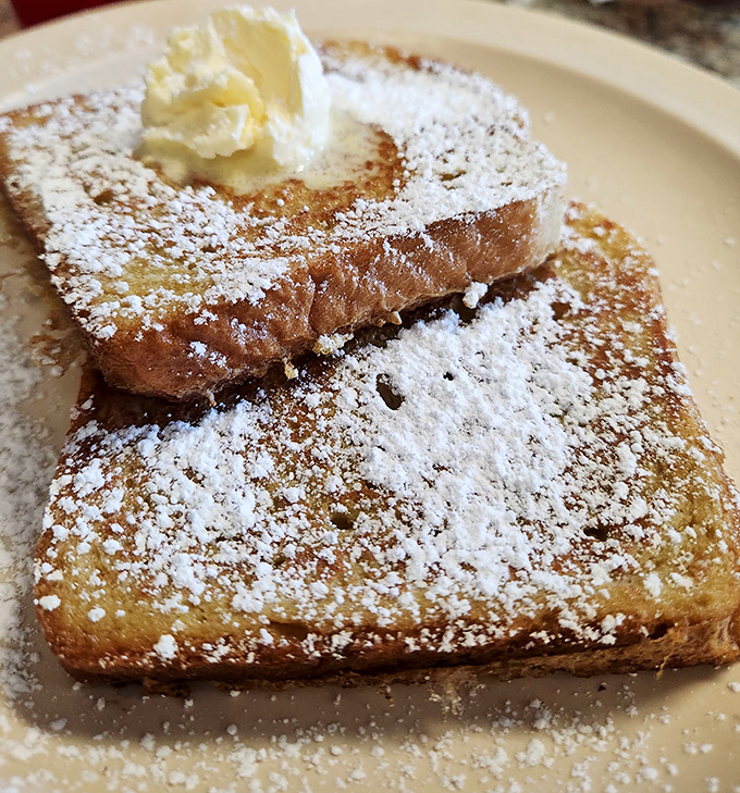 French toast that's dressed for success with a snow-like dusting of powdered sugar and a crown of butter slowly melting into golden perfection.