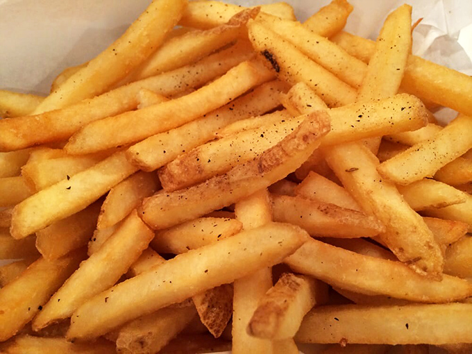 French fries dusted with pepper and salt, standing at attention like delicious soldiers ready to march straight into flavor country.