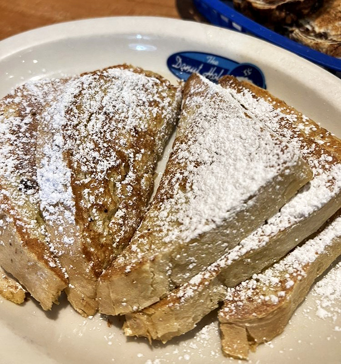 French toast that makes you question every other breakfast decision you've ever made. Powdered sugar snowfall on golden-brown perfection.