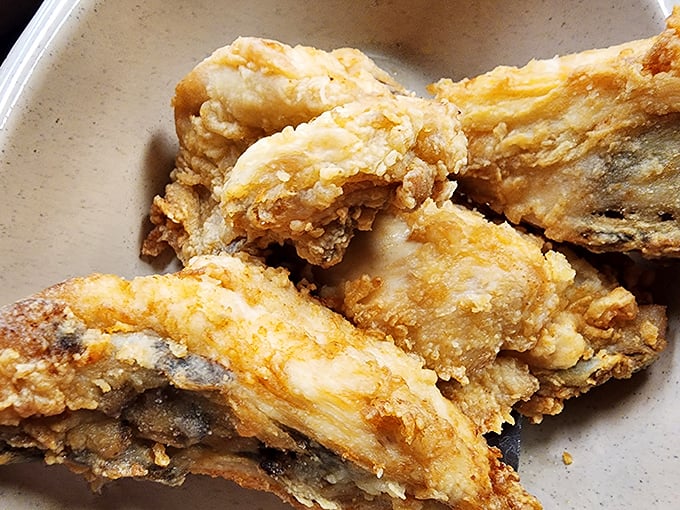 Fried chicken so perfectly golden it belongs in Fort Knox, with a crust that shatters like your diet willpower when you see it.