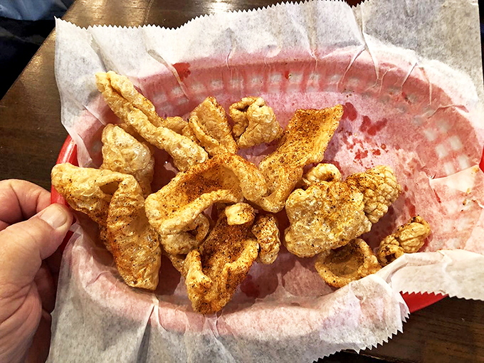 Pork skins that shatter like delicious glass, dusted with seasoning that makes your fingers worth licking. Potato chips just filed for early retirement.