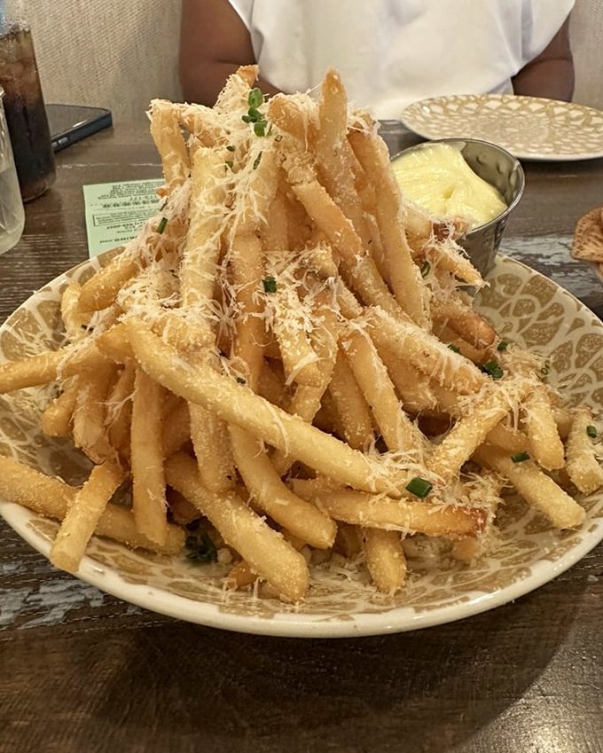 Parmesan truffle fries stacked like a golden tower of crispy, cheesy magnificence&mdash;the side dish that frequently steals the spotlight.