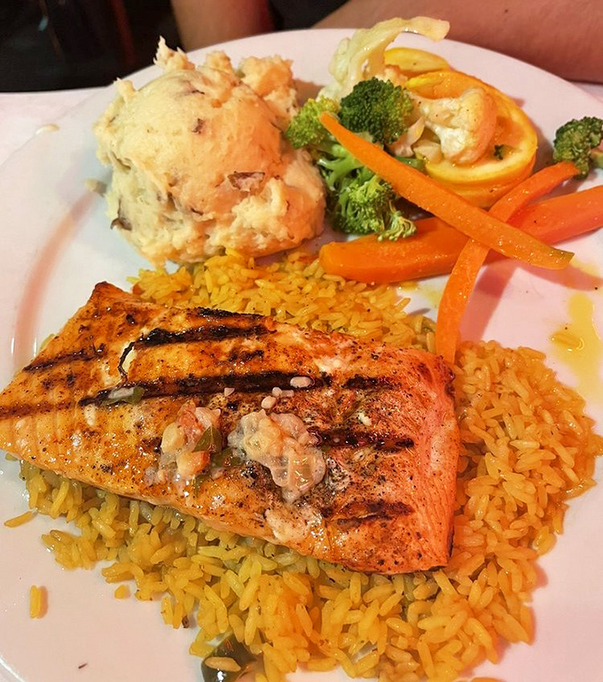 Grilled salmon for those pretending to be health-conscious at a steakhouse. The rice and vegetables are just there to ease your conscience.