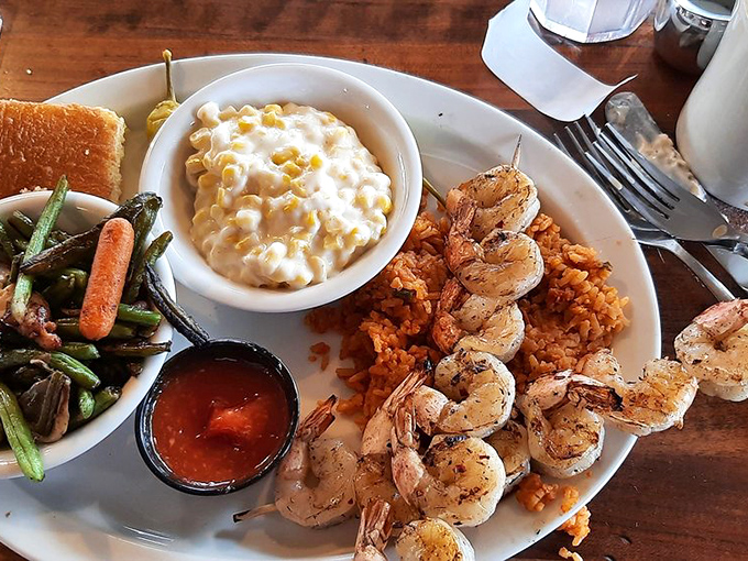 Grilled shrimp skewers resting on a bed of rice, with creamy corn and vegetables that remind you vegetables can actually taste amazing.