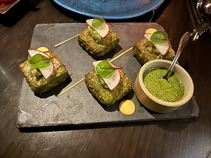 Hariyali Kebab squares present themselves like emerald jewels, adorned with radish medallions and mint chutney&mdash;proof that eating green can be an indulgence rather than a sacrifice.