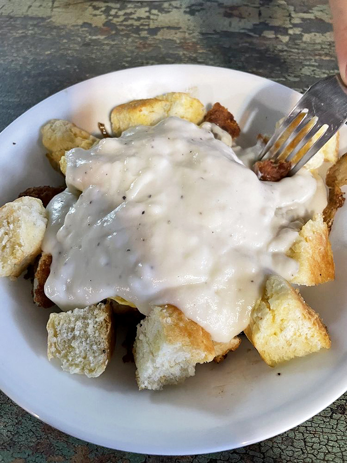 Comfort food architecture at its finest &ndash; tender chicken nestled under a blanket of gravy atop golden cubes of carb-laden bliss.