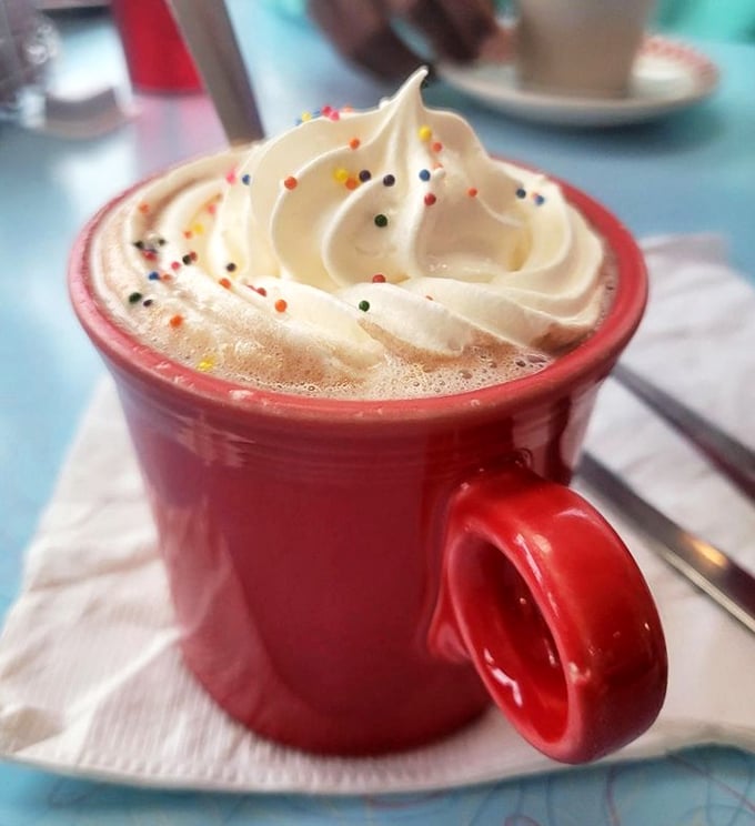 Hot chocolate that doesn't just arrive &ndash; it makes an entrance, topped with a cloud of whipped cream and sprinkles of childhood joy.