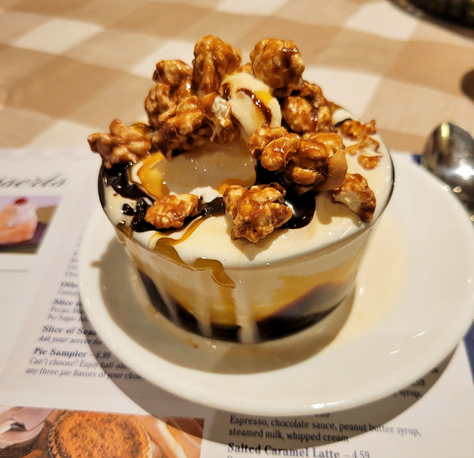 This sundae isn't just dessert; it's architecture. Layers of ice cream, sauce, and caramel popcorn creating a tower of sweet temptation that demands attention.