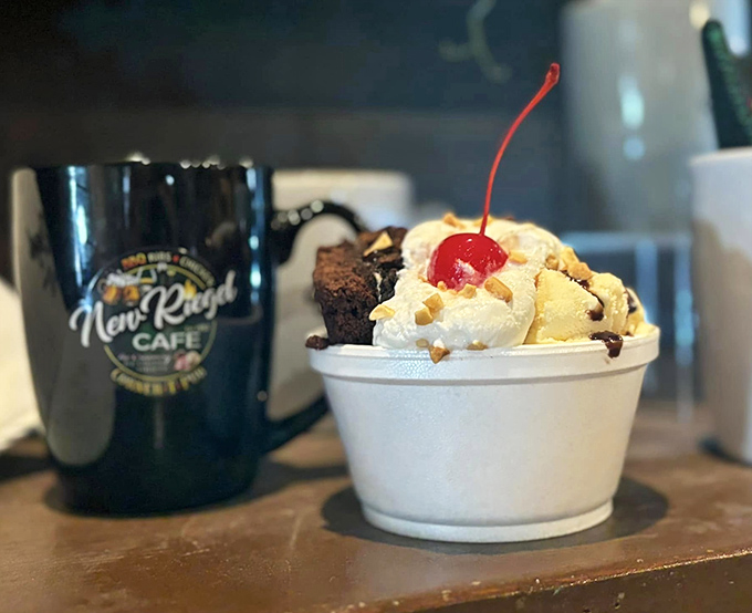 Ice cream sundae perfection beside a New Riegel mug – proof that sometimes the simplest desserts deliver the most profound happiness.